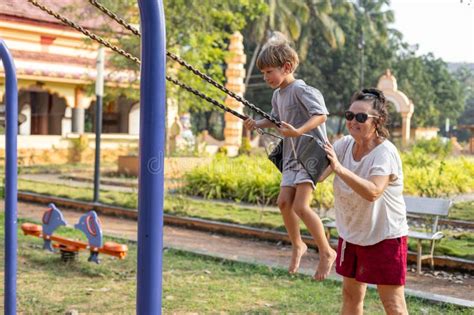 Grandma And Grandson Are Having Fun On Summer Day At Playground