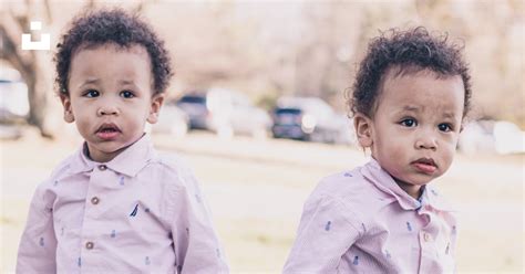 낮 동안 푸른 잔디밭에 서 있는 흰색 버튼 업 셔츠를 입은 소년 사진 Unsplash의 무료 유행 이미지