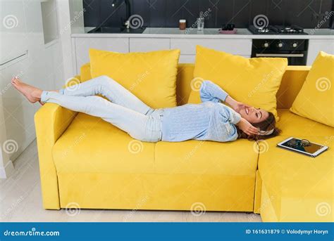 Pretty Blonde Teenage Girl In Headphones Is Listening To Music Looking
