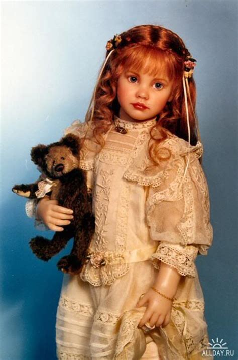A Doll With Red Hair Holding A Teddy Bear And Wearing A Wedding Dress