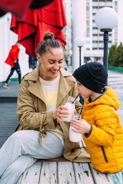 Premium Photo Young Mom And Son Have Fun And Drink Milkshake Outdoors