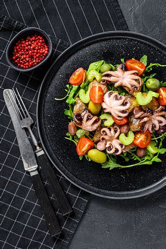 문어와 감자 아루굴라 토마토 올리브를 곁들인 홈메이드 샐러드 검은 색 배경입니다 맨 위 보기 0명에 대한 스톡 사진 및 기타