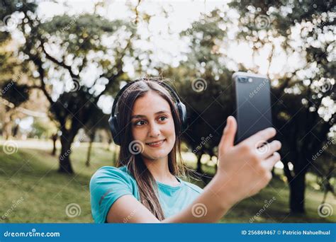 Smiling Teenage Girl Wearing A Turquoise T Shirt And Headphones Taking