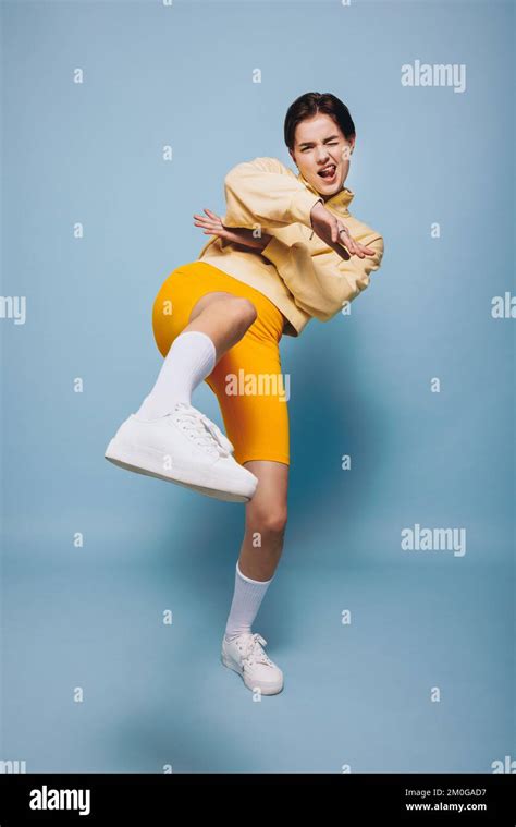 Energetic Young Woman Winking At The Camera While Doing Some Fun Dance