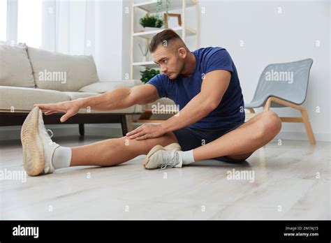 Man Sportsman Training At Home Stretching Exercises For Arm Leg And