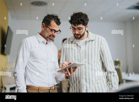 Cross Generational Colleagues Collaborating On New Project And