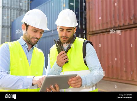 View Of A Dock Worker And Supervisor Checking Containers Data On Tablet