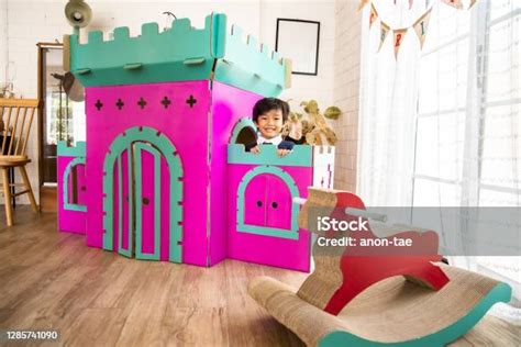 부모가 함께 집에서 휴식을 취하는 동안 놀고있는 귀여운 아이들은 종이 장난감 흔들리는 말 행복한 가족이 주말에 거실에서 함께 시간을 보내는 미소로 즐겁게 웃고 있습니다