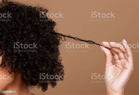 헤어 케어 뷰티 스튜디오에서 갈색 배경에 곱슬머리를 한 흑인 여성 손 미용실 웰빙 및 성장 자연스럽고 건강한 모발을 위한 컬