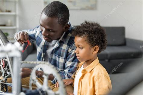 Afro Padre E Hijo Reparando Bicicleta 2023