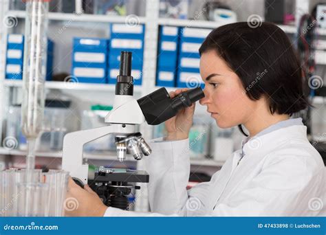 Giovane Donna Dello Scienziato Che Utilizza Un Microscopio Nel