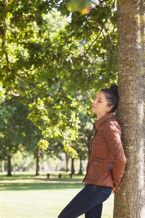Attractive Woman Leaning Against A Tree With Closed Eyes Stock Image