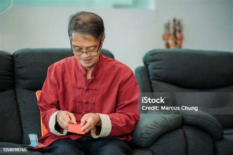 아시아 중국 미소 노인 은 중국 설날 동안 거실에서 빨간 봉투에 돈을 넣어 70 79세에 대한 스톡 사진 및 기타 이미지