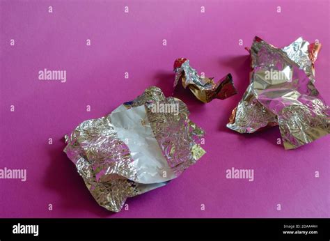 Lots Of Crumpled Shiny Candy Wrappers On Pink Background Empty Chocolate Candy Wrappers