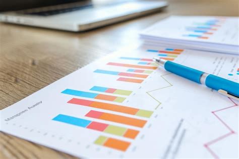 Closeup Of Desk With Blue Pen On Data Analysis Report Displaying Bar