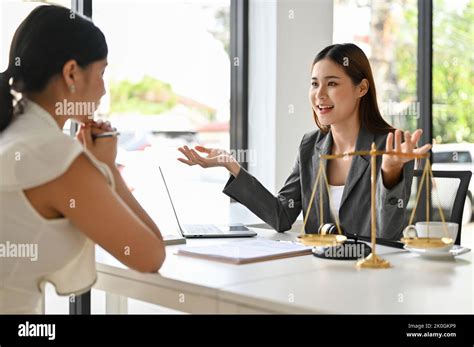 Beautiful And Cheerful Asian Female Lawyer Or Business Legal Consultant