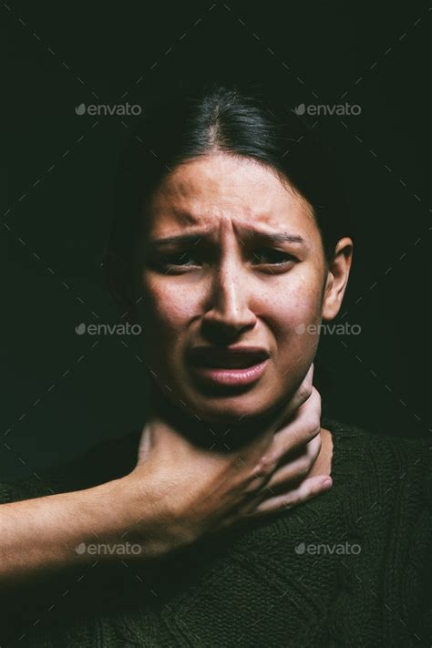 Shot Of A Young Woman Being Strangle By An Unrecognisable Man Against A