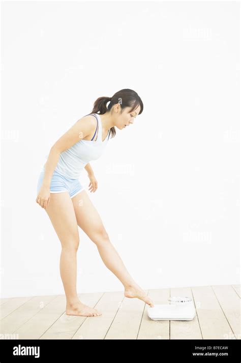 Woman Getting On The Scale Stock Photo Alamy