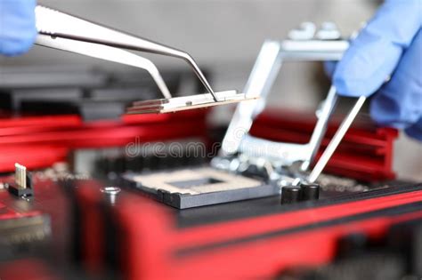PC CPU Intel In The Hands Of A Technician Against The Background Of The Motherboard Gigabyte