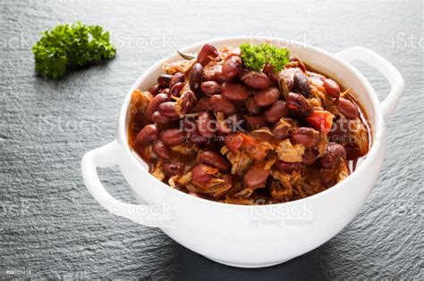 양파 파프리카 맥주 벨 핑크 후추 매운 토마토 소스에 돼지고기와 콩 조 림 화이트 수프 그릇 고 검은 돌에 신선한 파 슬 리 0명에 대한 스톡 사진 및 기타 이미지 Istock