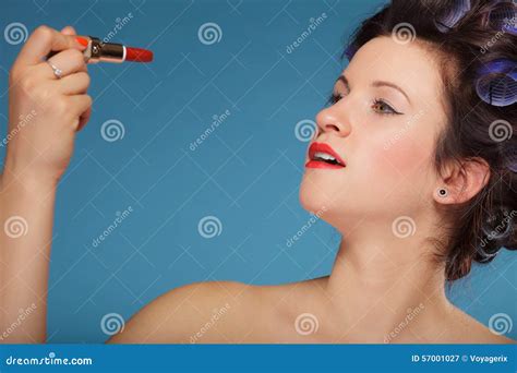 Menina Nos Encrespadores De Cabelo Que Aplicam O Batom Vermelho Imagem