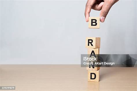 책상 위에 Brand라고 쓰인 나무 블록을 손으로 올려놓는 모습 마케팅 전략 브랜딩 성장 및 사업 개발 개념에 대한 일러스트레이션 개념에 대한 스톡 사진 및 기타 이미지