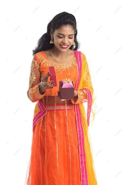 A Cheerful Indian Maiden Grinning With Joy While Carrying Gift Boxes In A White Setting Photo