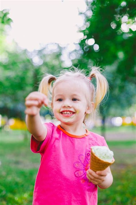 Little Funny Girl Blonde Eating Sweet Blue Ice Cream In A Waffle Cup On