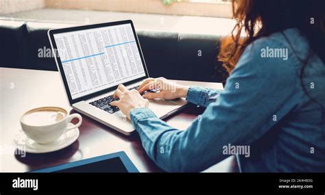 Midsection Of Caucasian Female Programmer Sitting With Coffee Using