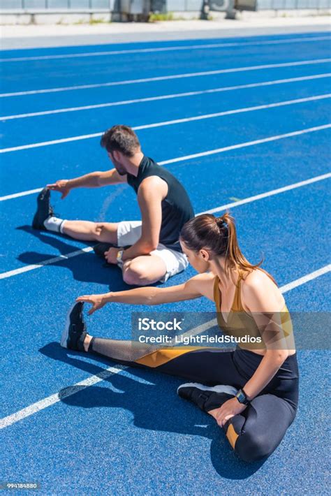 젊은 운동 남성과 여성 조깅 실행 추적에 앉아서 스트레칭의 높은 각도 보기 건강한 생활방식에 대한 스톡 사진 및 기타 이미지 건강한 생활방식 남성 단거리 경기