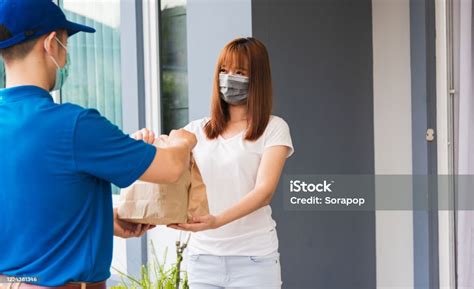 아시아 배달 특급 택배 젊은 남자 종이 가방 패스트 푸드를 주는 여자 고객 에 보호 얼굴 마스크 통행 금지 검역 전염병 전염병