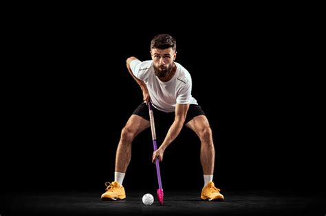 스포츠 유니폼을 입은 청년과 어두운 배경에 고립 된 플로어 볼을 연주하는 운동화의 스튜디오 샷 스포츠 액션 및 모션 움직임 경쟁 플로어볼에 대한 스톡 사진 및 기타 이미지