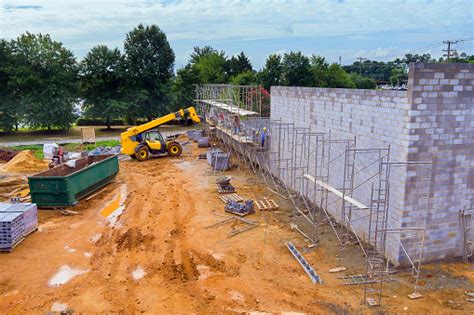 비계 위에 서 있는 석조 작업자가 시멘트 블록을 사용하여 콘크리트 벽을 만들고 있습니다 건설 산업에 대한 스톡 사진 및 기타 이미지 건설 산업 건설 현장 건물 외관