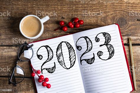 책상 위에 2023년 새해 결심 2023년 결의안 목록에는 노트북 커피 컵 테이블 장식이 있습니다 목표 결의안 계획 행동 개념