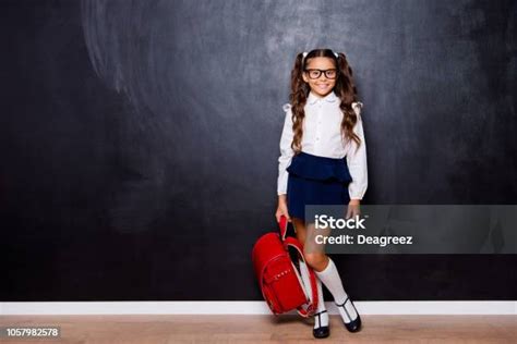 크기 몸 길이 다행 소녀의 수줍음 좋은 스마트 귀여운 작은 소녀 빨간 가방 흰 블라우스 셔츠와 블루 스커트에 묶은 곱슬 머리와의 전체 검은 배경에 절연 교육에 대한 스톡