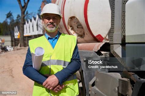 안전모를 쓴 건설 노동자와 청사진을 들고 서 있는 Hi Vis 안전 조끼 건설 현장에 대한 스톡 사진 및 기타 이미지 건설