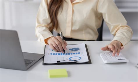 사무실 책상 세금 보고서 회계 통계 및 분석 연구 개념에서 수학 금융을 수행하기 위해 계산기와 노트북을 사용하는 아시아 비즈니스 여성 경영자에 대한 스톡 사진 및 기타