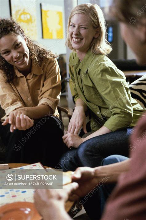 Two Young Women And A Young Man Playing Scrabble Superstock