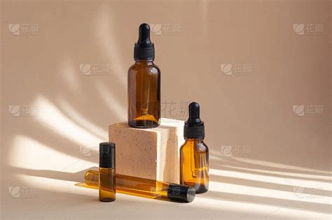四个不同形状的棕色玻璃瓶，米色背景上有阳光下的阴影。3d广场平台，用于演示。护肤的概念。天然的化妆品素材 花瓣网
