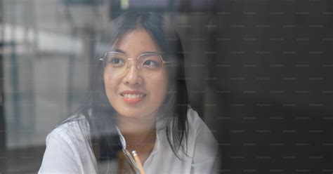 유리 벽을 통해 여성 노동자가 웃고 직장 창 밖의 전망을 즐기며 보는 전망 사진 Unsplash의 태국 이미지