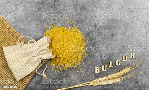 삶은 말린 밀로 만든 시리얼 벌거 어두운 배경에 가방에서 곡물이 쏟아져 나왔다 위쪽 보기 쿠스쿠스 주식에 대한 스톡 사진 및