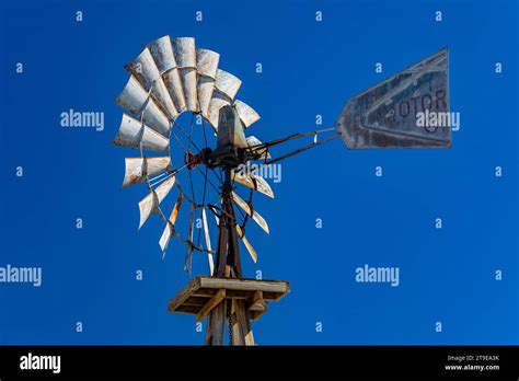 Windmill With Wooden Town Structure Pumping Water For Cattle And