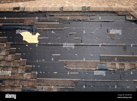 Damaged House Roof With Missing Shingles After Hurricane Ian In Florida