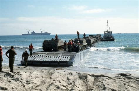 Ground Support Equipment Is Transported From A Causeway To Shore From