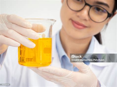 화학 여자는 질병 Dna 전문 연구 결과를 연구하는 의료용 유리 플라스크를 들고 액체 용액을 분석합니다 25 29세에 대한 스톡