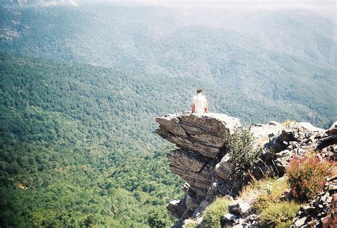 Фото Парень сидит на краю скалы