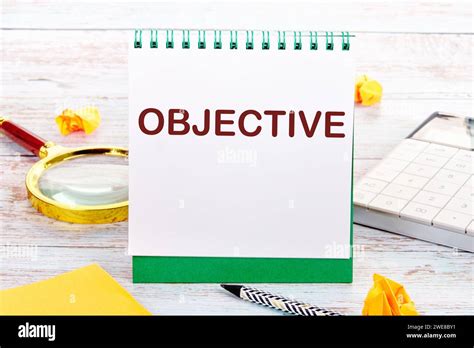 Objective Text On The White Sheet Of The Notebook Is Next To A
