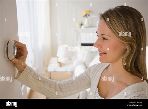 Woman Adjusting Thermostat Stock Photo Alamy