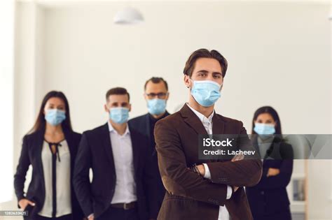 남성 리더와 책임있는 젊은 회사 노동자의 팀은 모두 직장에서 얼굴 마스크를 착용 20 24세에 대한 스톡 사진 및 기타 이미지