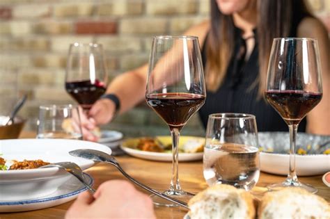 Premium Photo Midsection Of Woman Holding Wine Glass On Table
